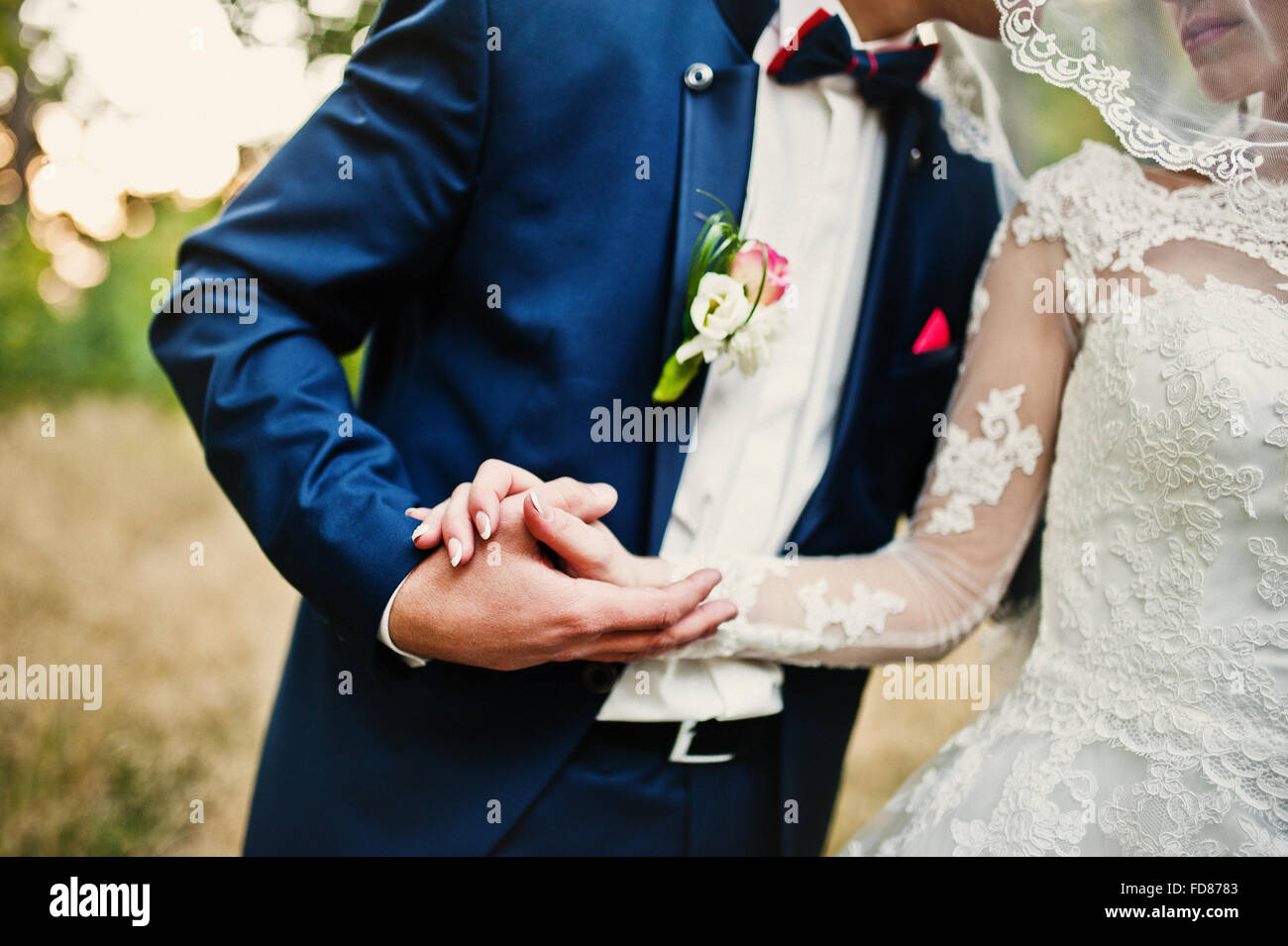 Hand in hand of stylish wedding couple Stock Photo - Alamy