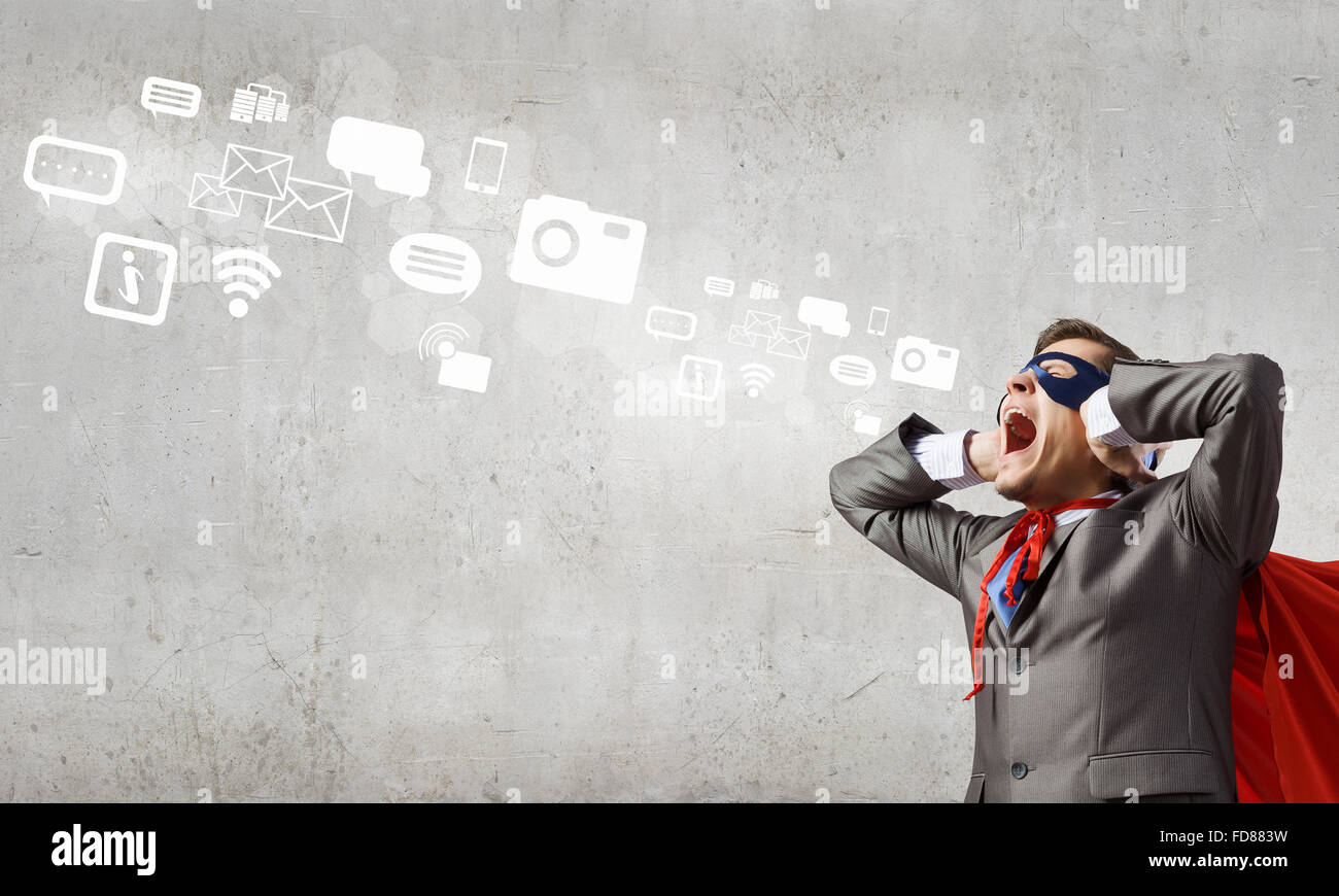 Young man in hero costume closing ears with palms Stock Photo - Alamy