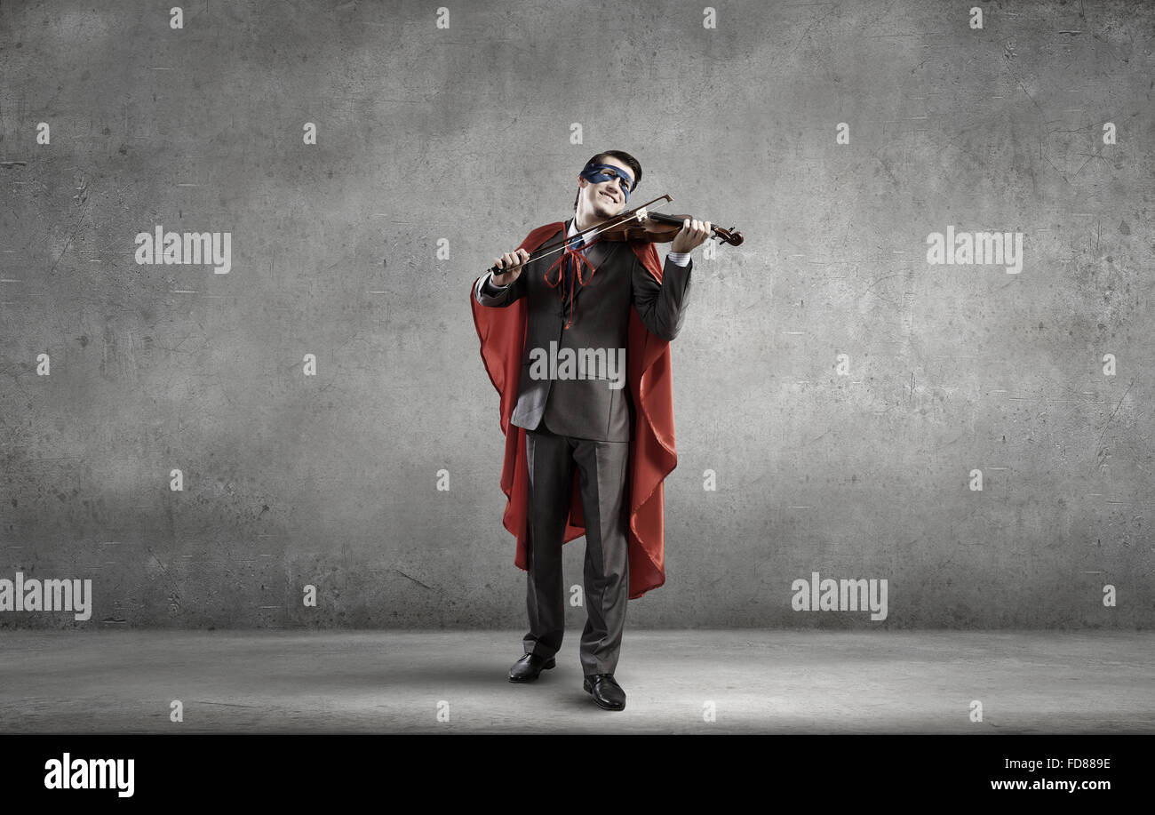 Young man in superhero costume playing violin hi-res stock photography ...