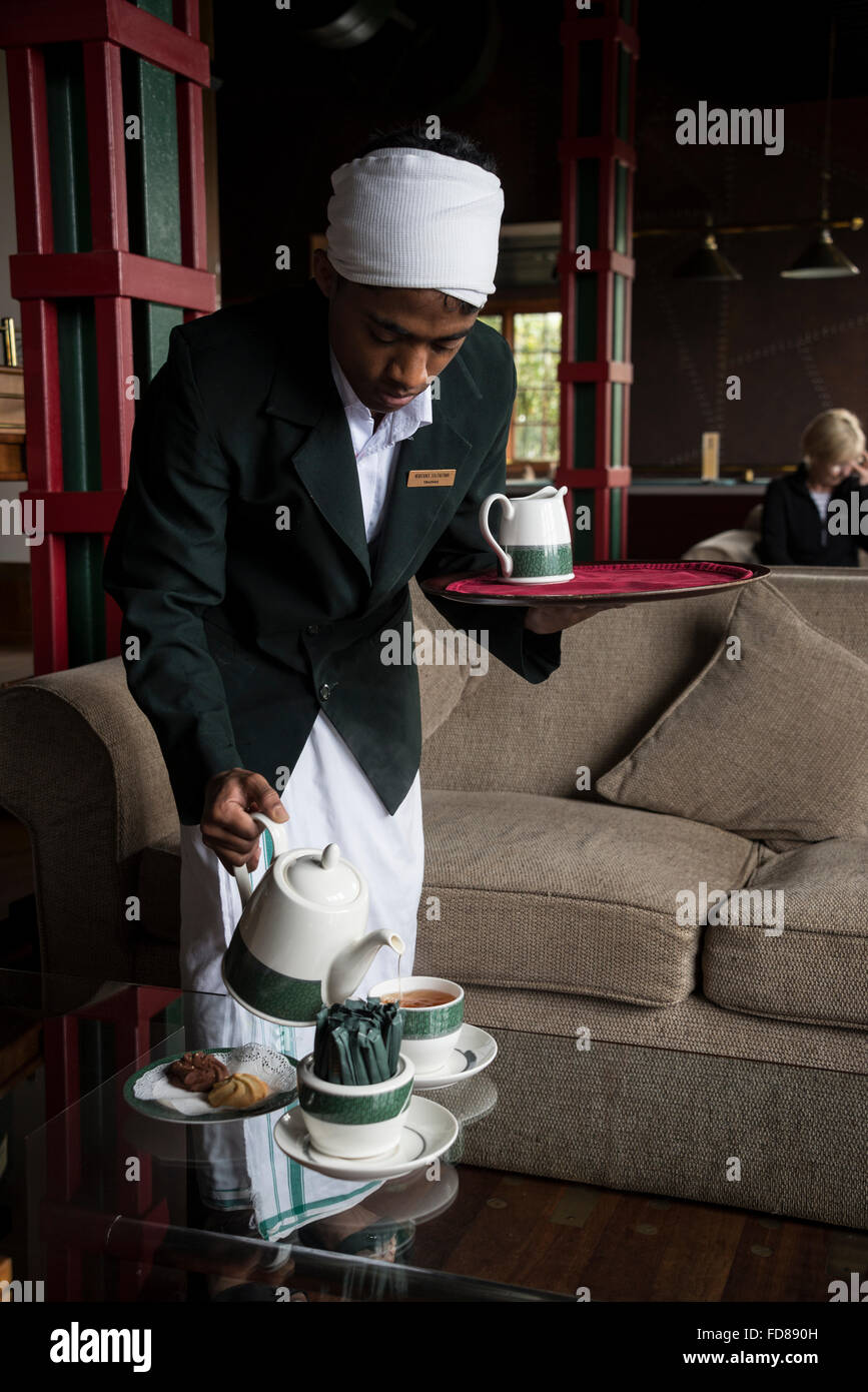 A tea boy a member of the hotel staff, serving locally grown tea at the ...