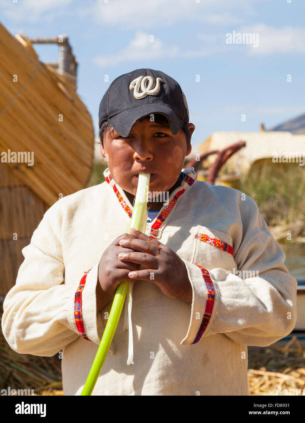 Uros Indian boy chewing cane Stock Photo - Alamy