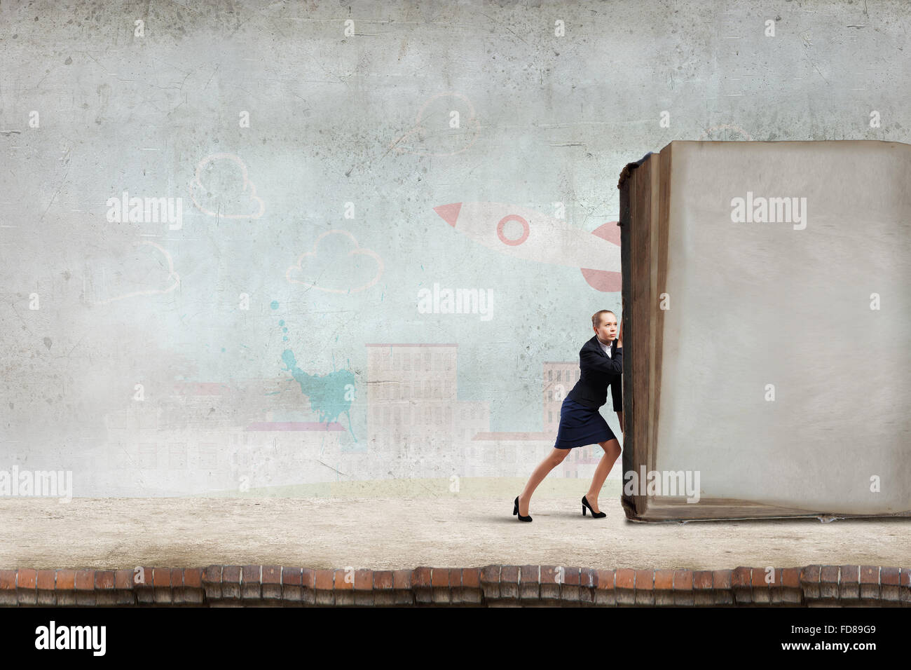 Young woman making effort to push huge old book Stock Photo - Alamy