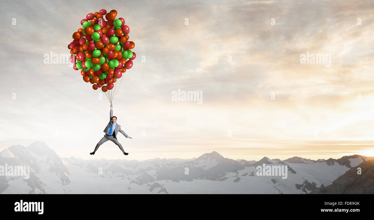Young successful businessman flies on bunch of colorful balloons Stock ...