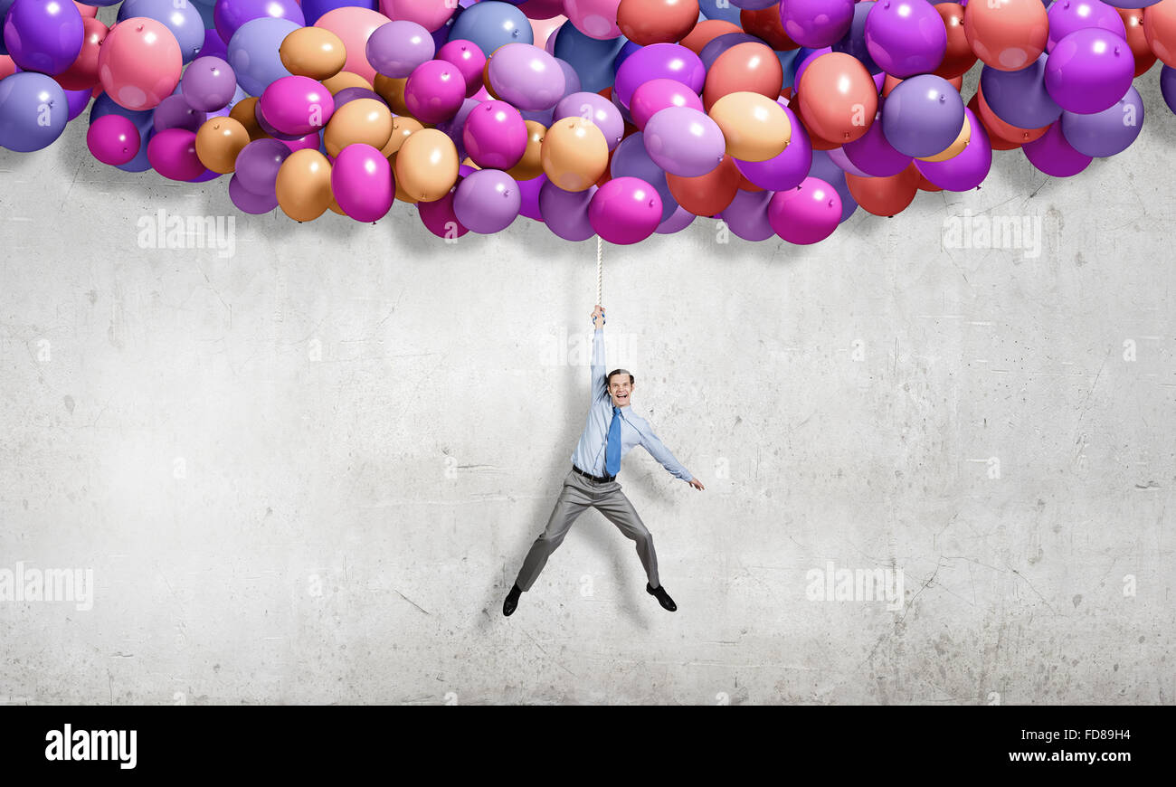 Young successful businessman flies on bunch of colorful balloons Stock ...