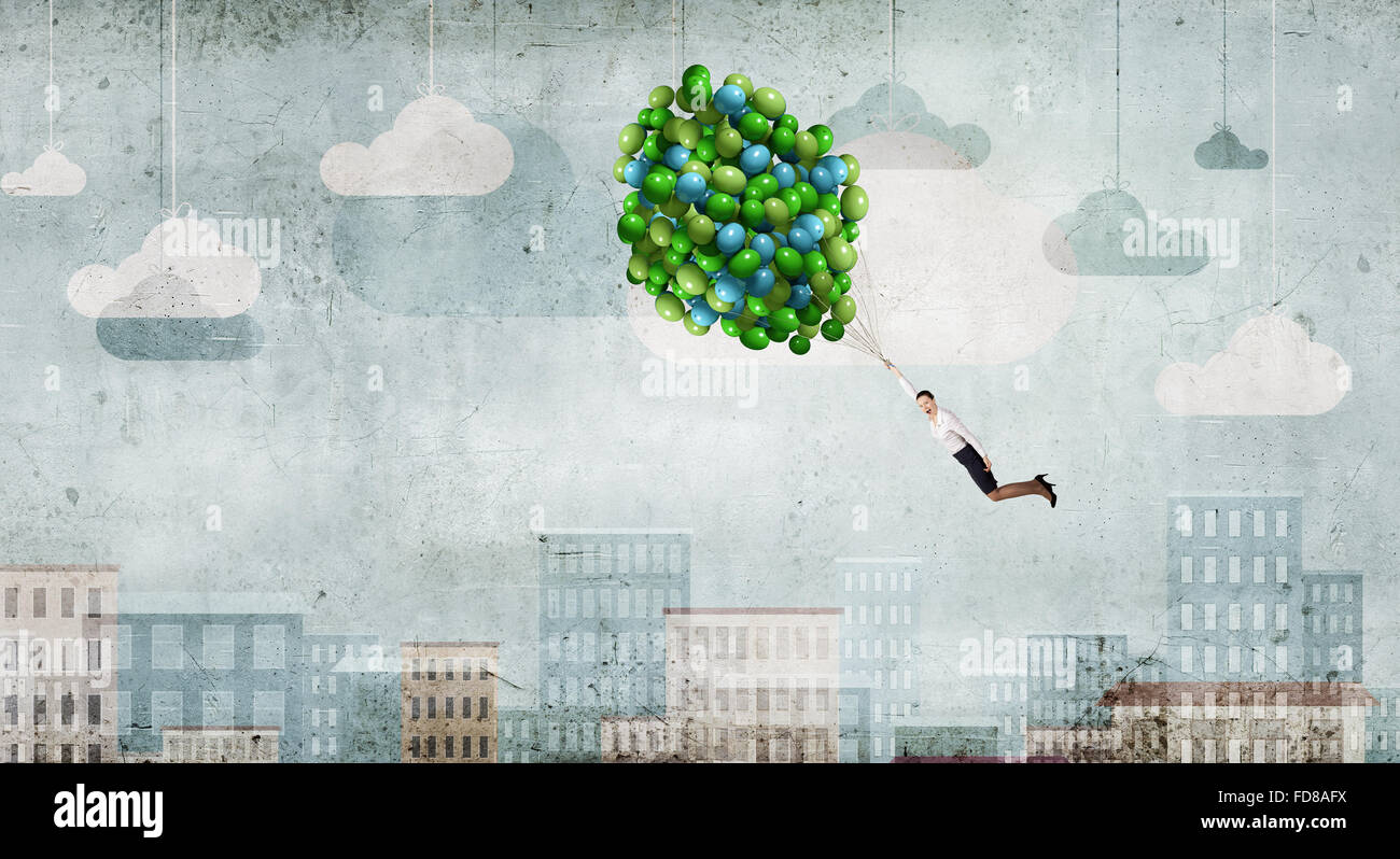 Young businesswoman flying high in sky on bunch of balloons Stock Photo ...