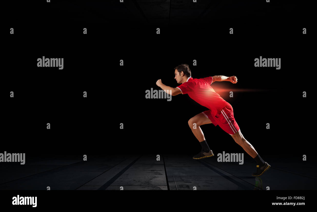 Running man in red sport wear on black background Stock Photo - Alamy
