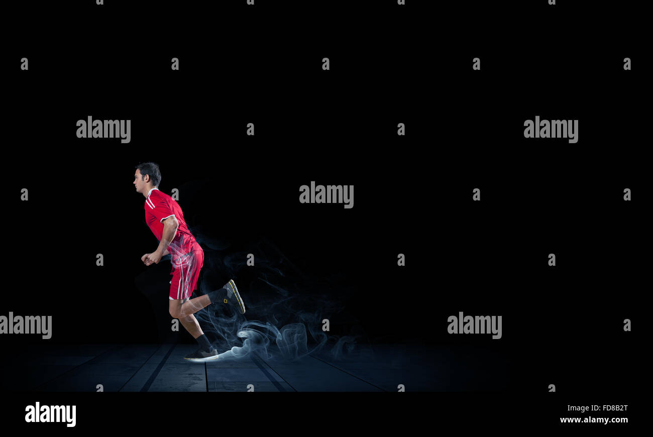 Running man in red sport wear on black background Stock Photo - Alamy