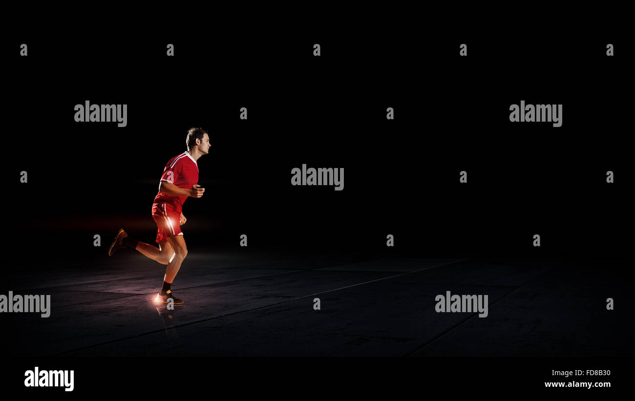 Running man in red sport wear on black background Stock Photo - Alamy