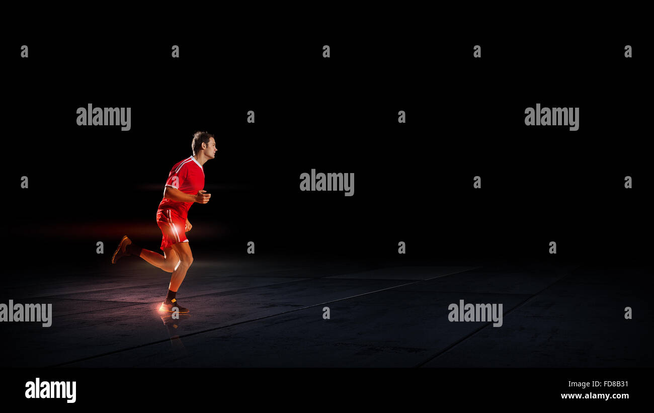 Running man in red sport wear on black background Stock Photo - Alamy