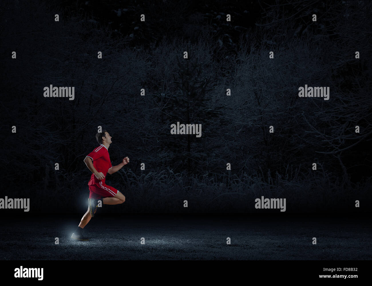 Running man in red sport wear on black background Stock Photo - Alamy