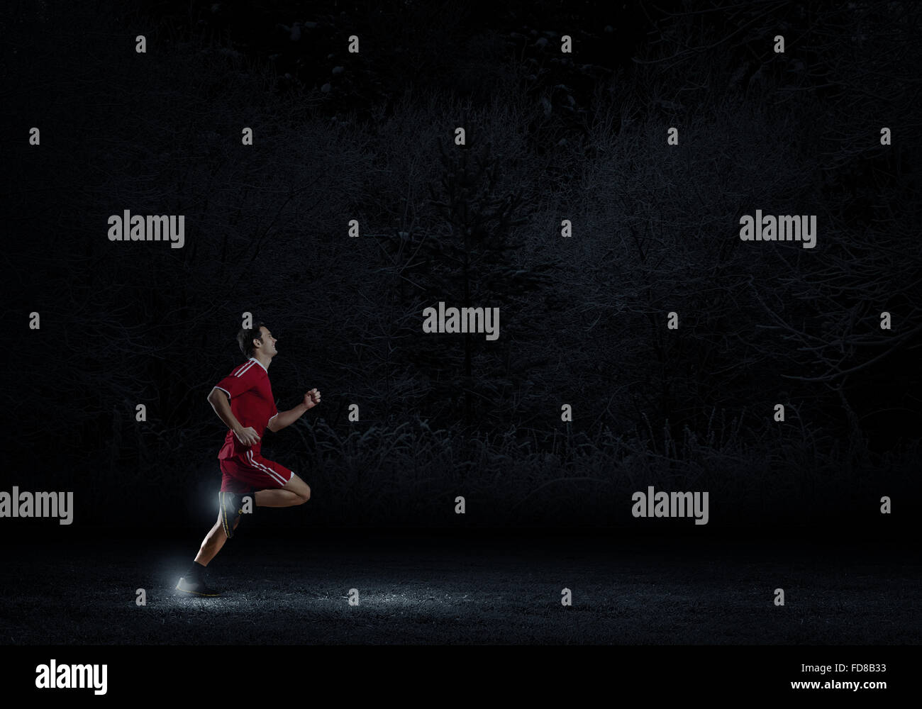Running man in red sport wear on black background Stock Photo - Alamy