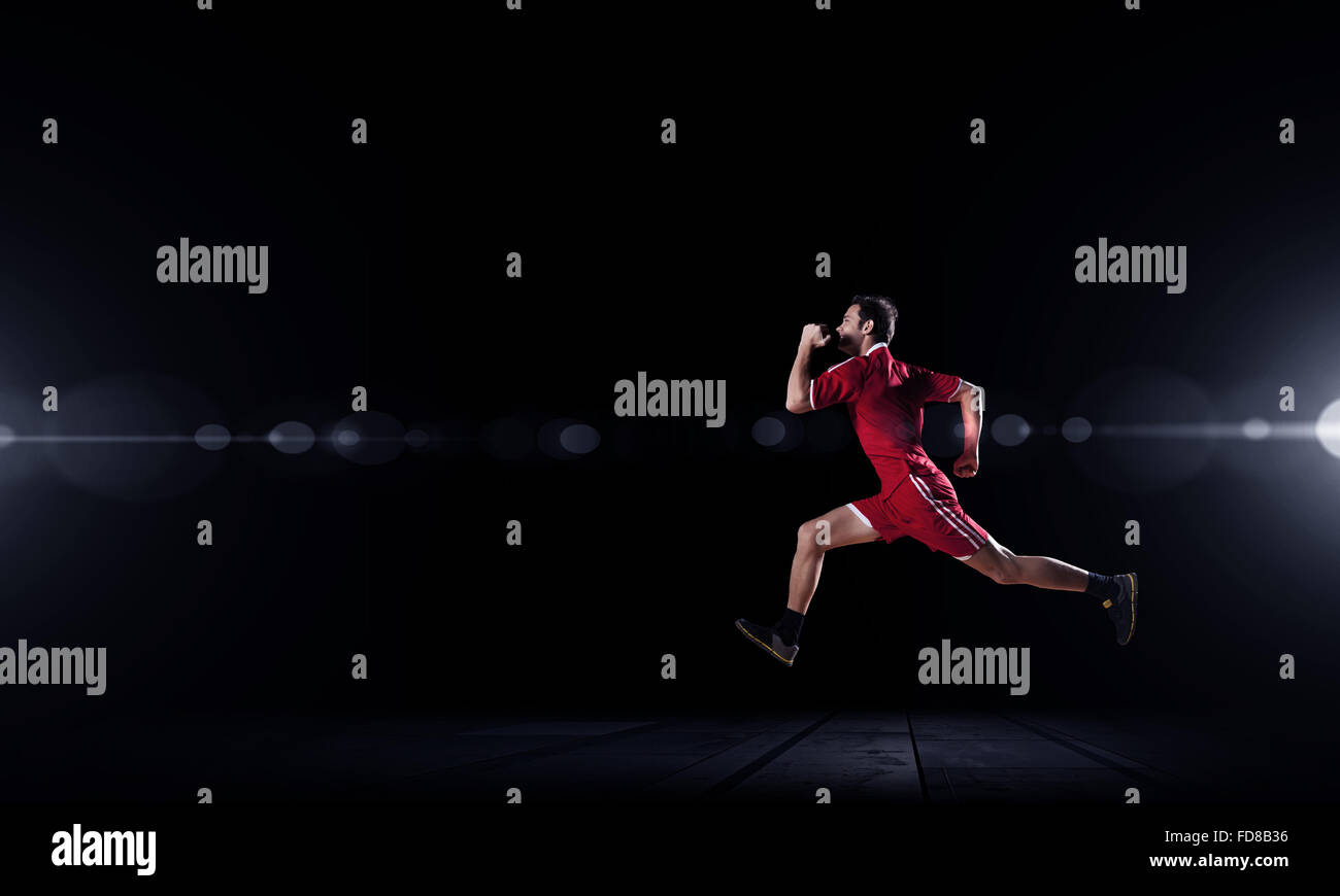 Running man in red sport wear on black background Stock Photo - Alamy