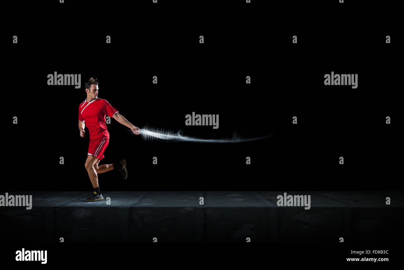 Running man in red sport wear on black background Stock Photo - Alamy