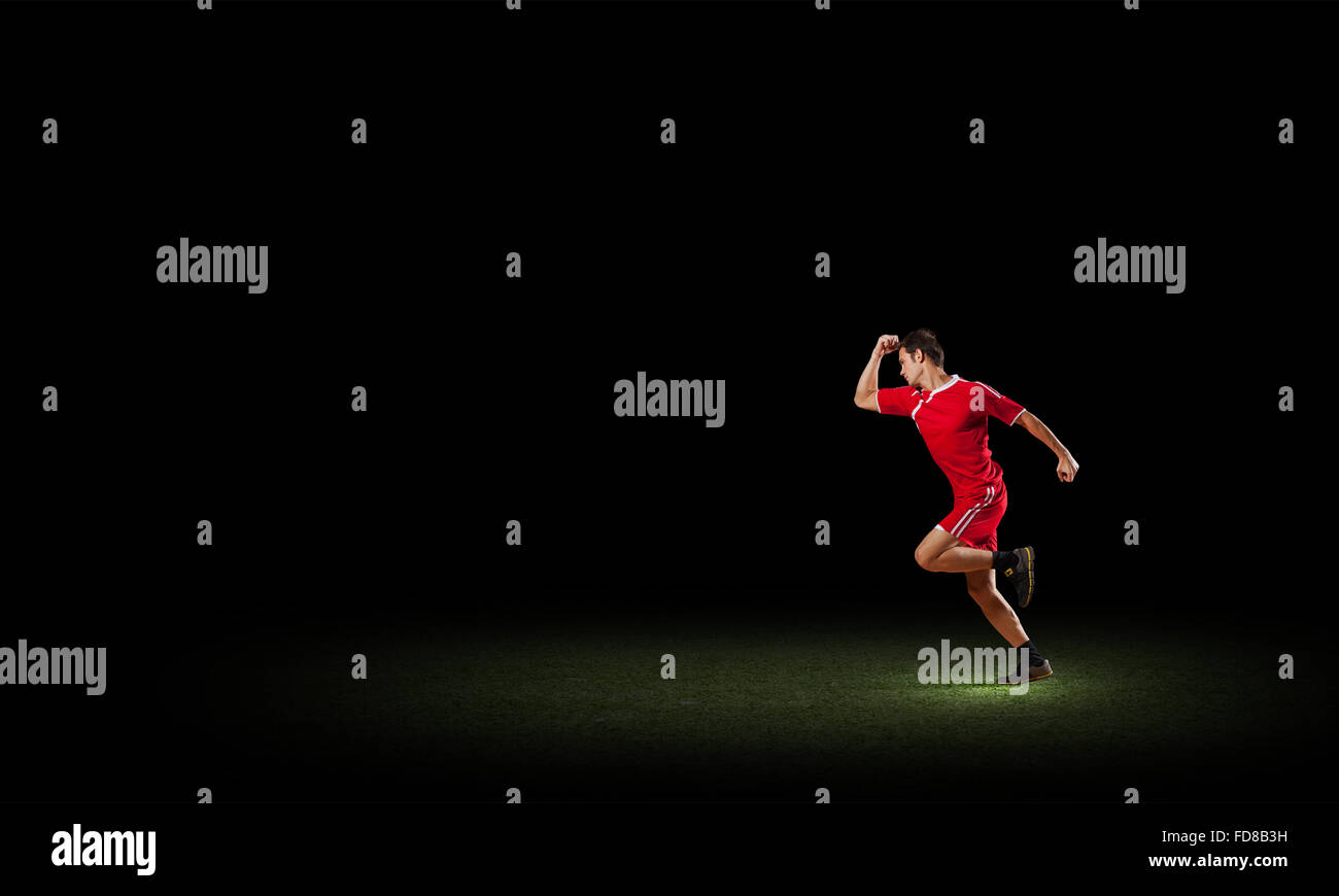 Running man in red sport wear on black background Stock Photo - Alamy