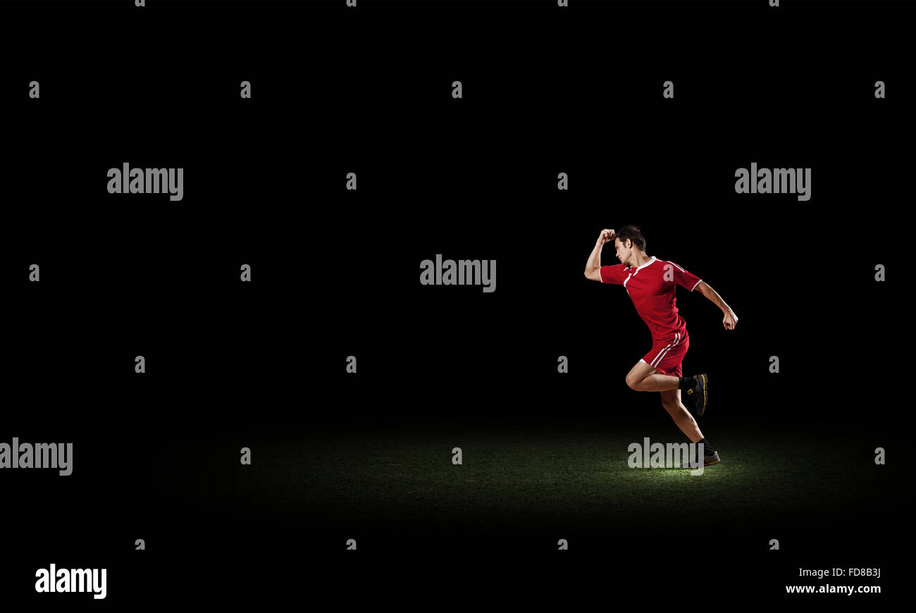 Running man in red sport wear on black background Stock Photo - Alamy