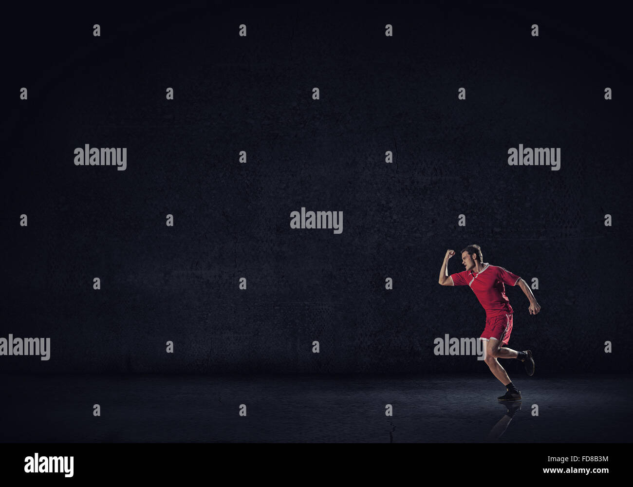 Running man in red sport wear on black background Stock Photo - Alamy