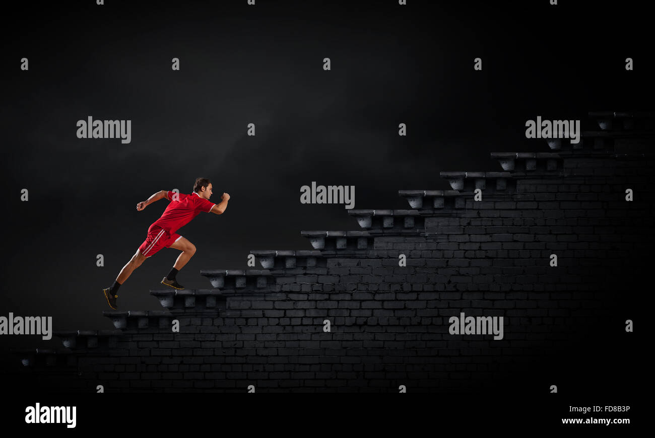 Running man in red sport wear on black background Stock Photo - Alamy