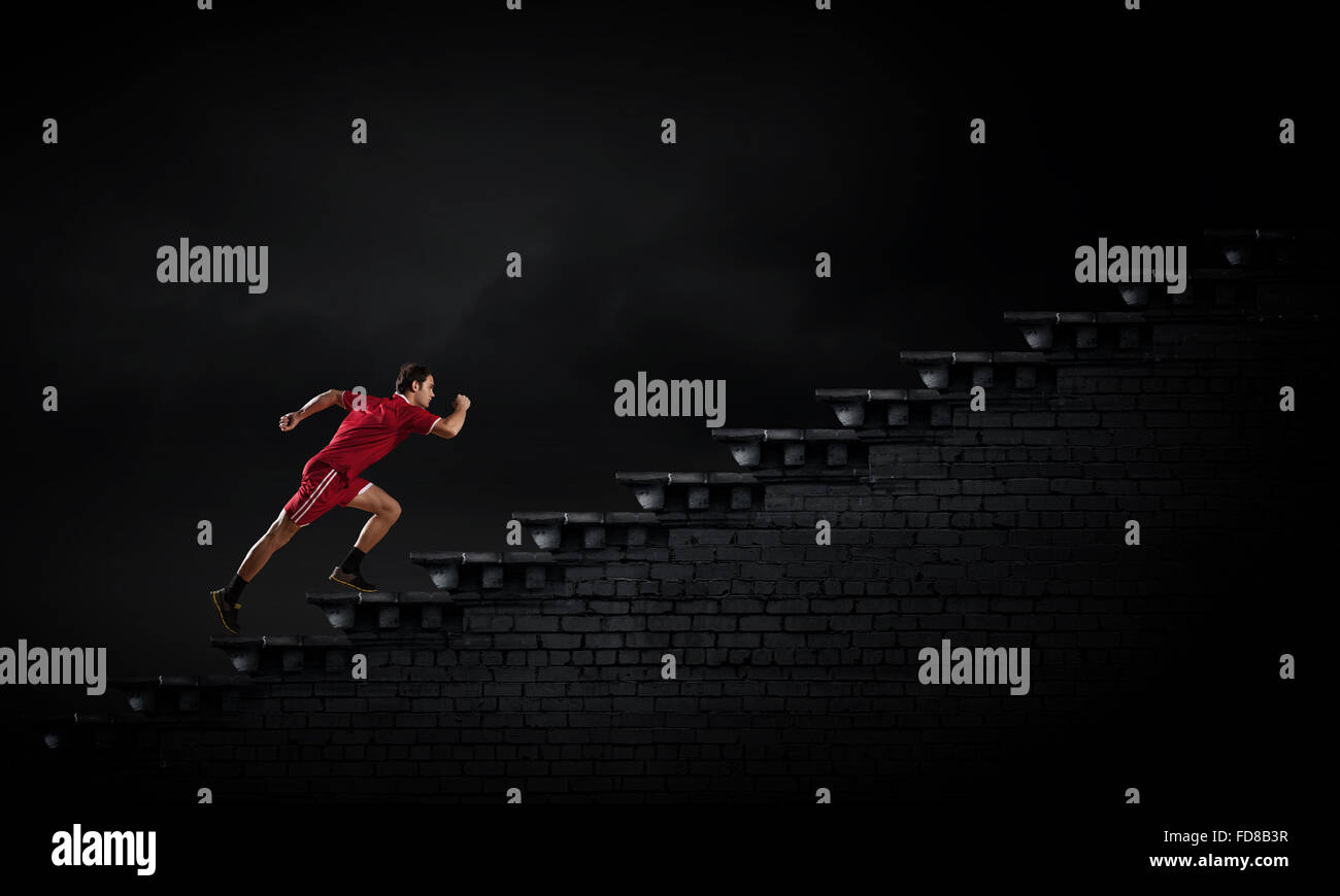 Running man in red sport wear on black background Stock Photo - Alamy