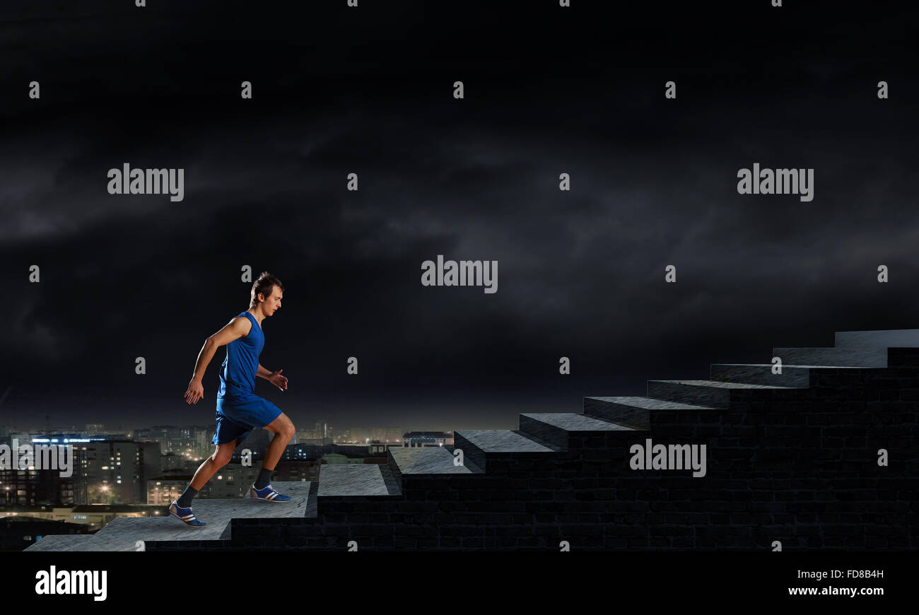 Running man in blue sport wear on black background Stock Photo - Alamy