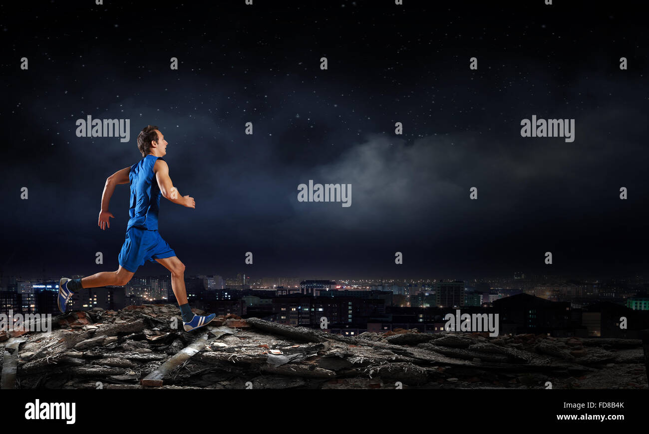 Running man in blue sport wear on black background Stock Photo - Alamy