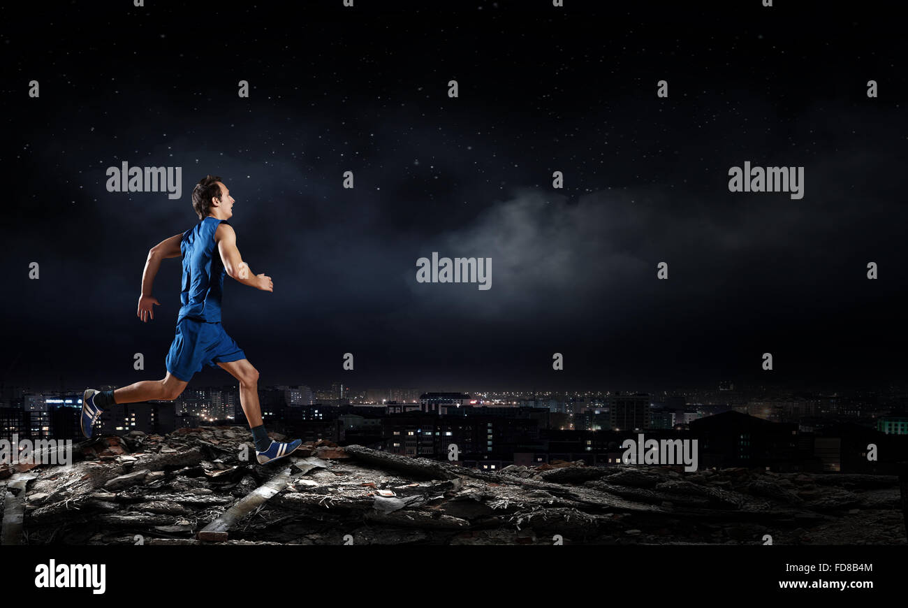 Running man in blue sport wear on black background Stock Photo - Alamy