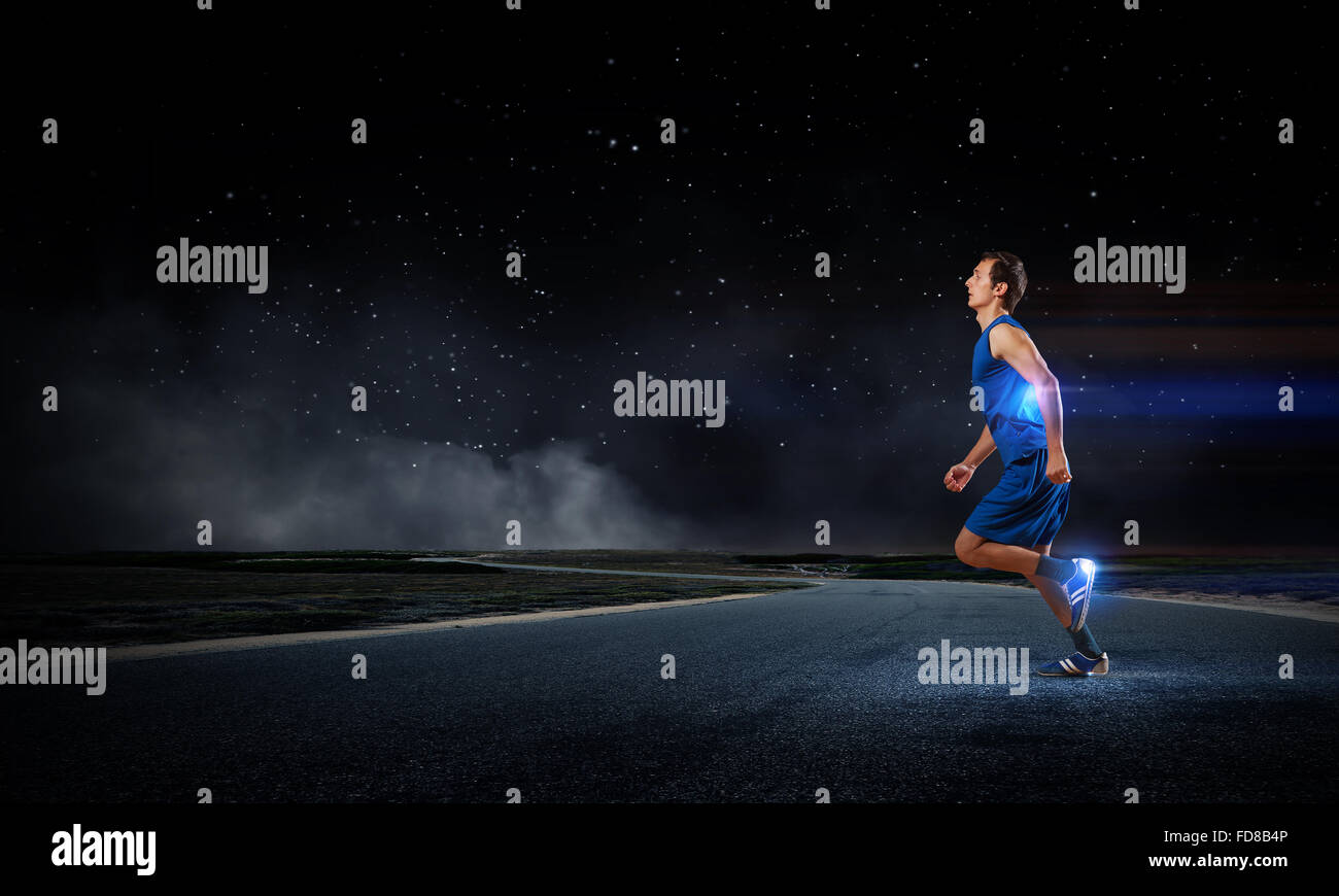 Running man in blue sport wear on black background Stock Photo - Alamy