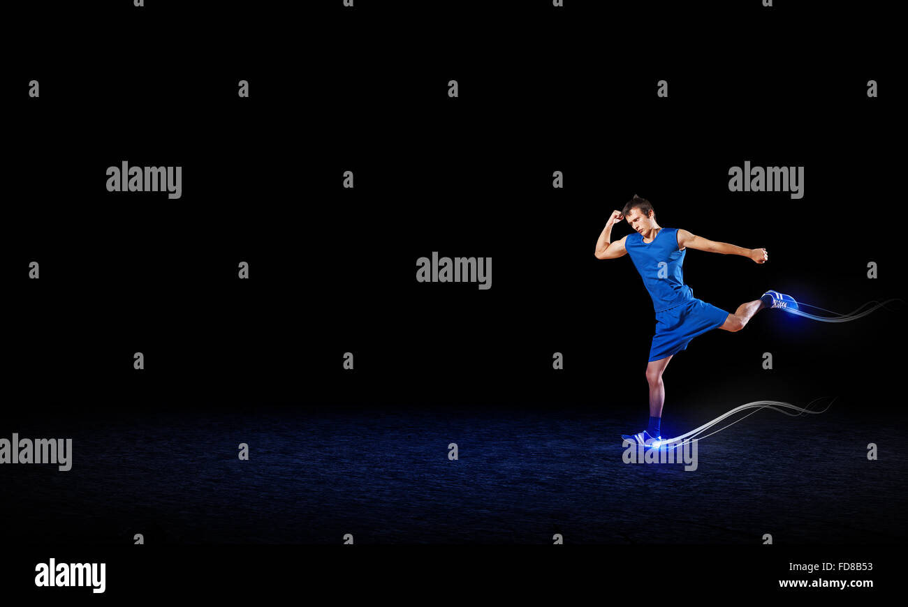 Running man in blue sport wear on black background Stock Photo - Alamy