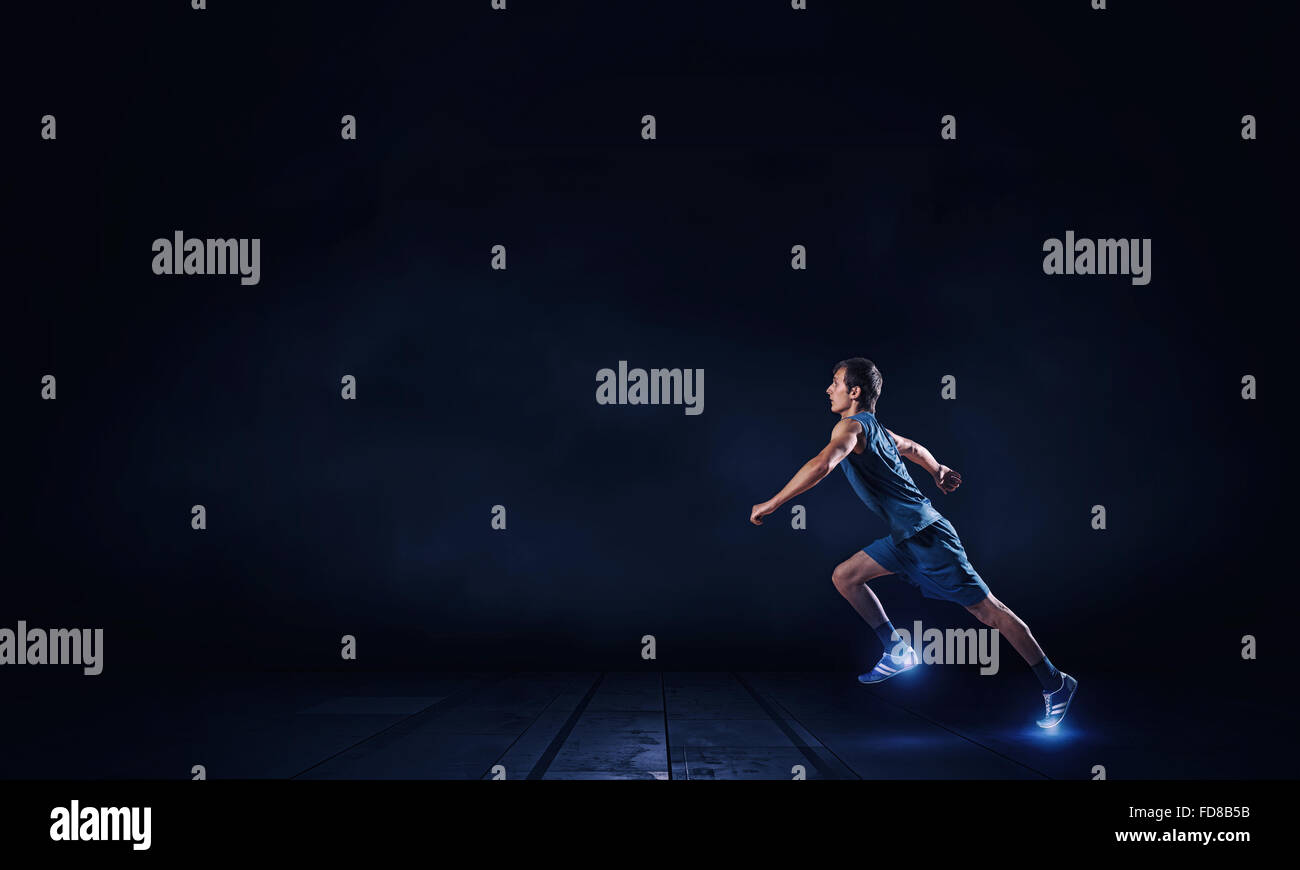 Running man in blue sport wear on black background Stock Photo - Alamy