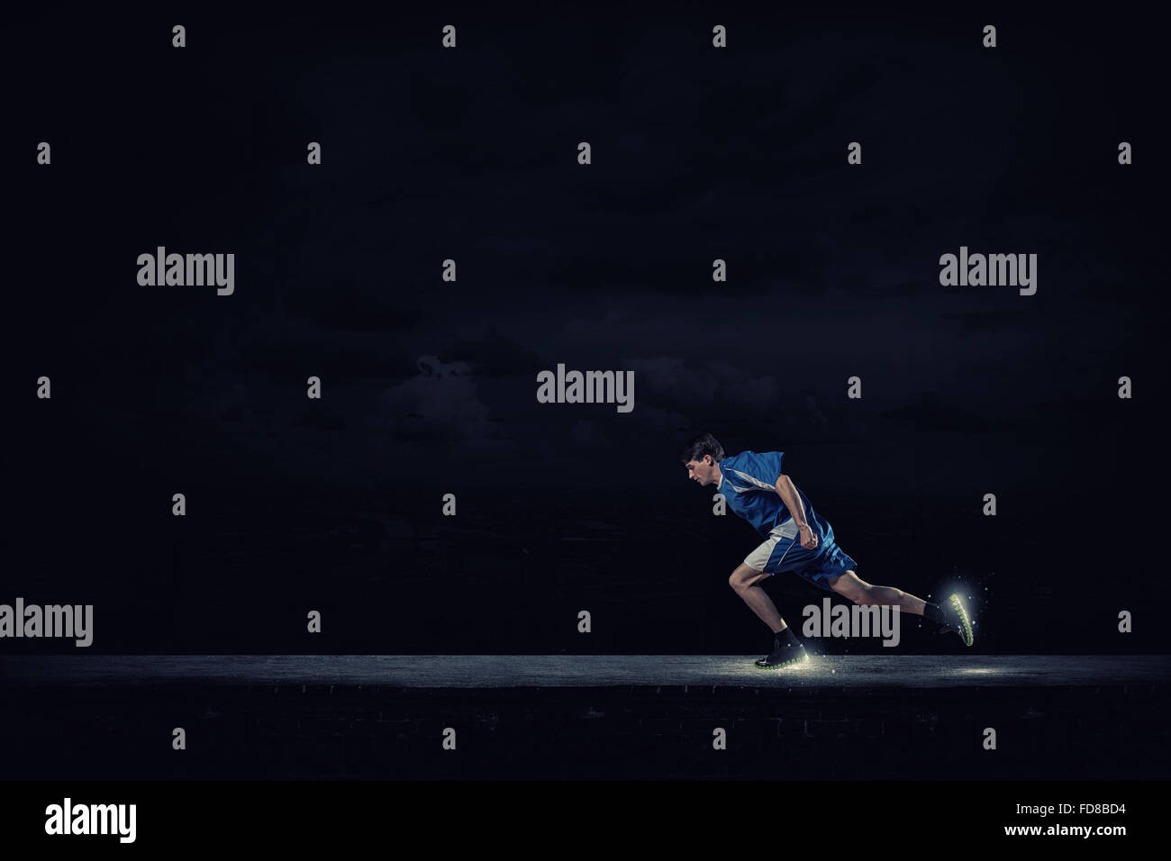 Running man in blue sport wear on black background Stock Photo - Alamy