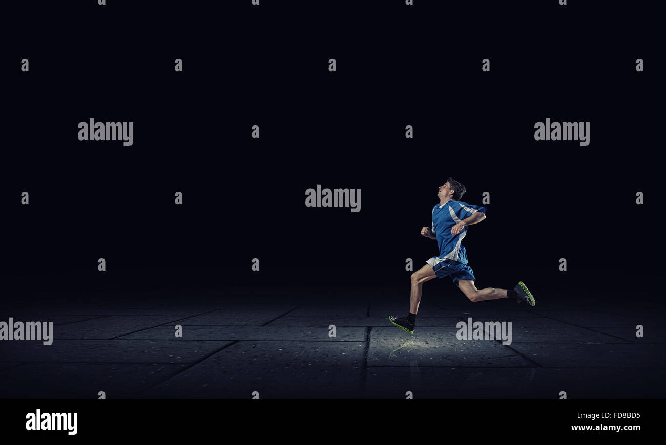 Running man in blue sport wear on black background Stock Photo - Alamy