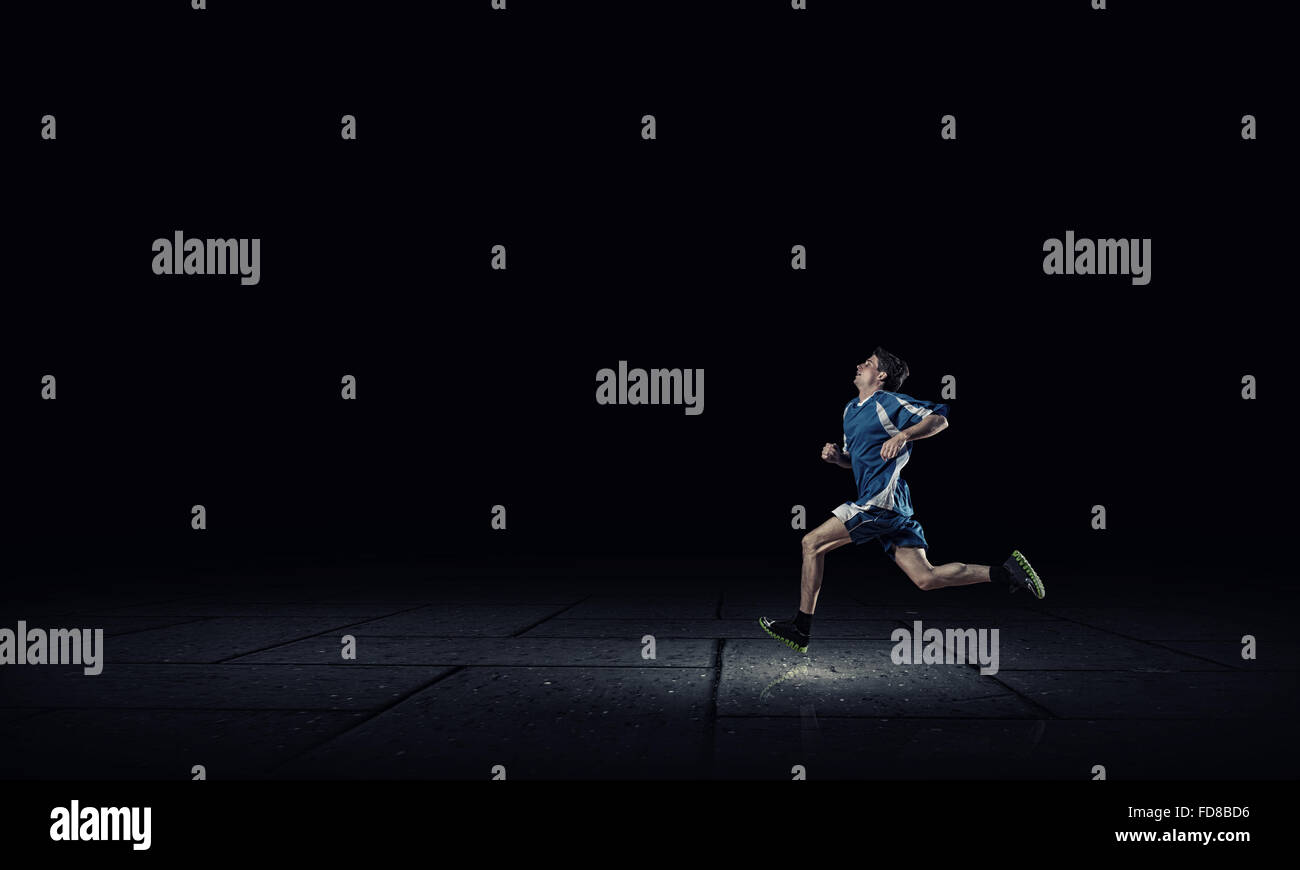 Running man in blue sport wear on black background Stock Photo - Alamy