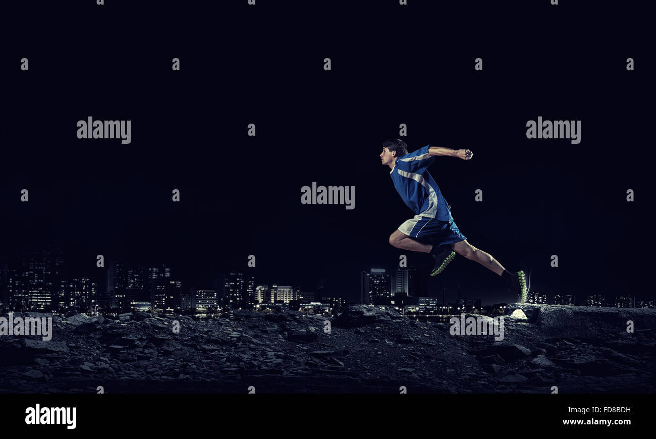 Running man in blue sport wear on black background Stock Photo - Alamy