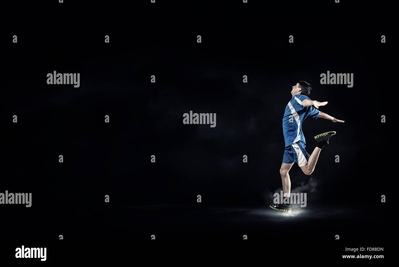 Running man in blue sport wear on black background Stock Photo - Alamy