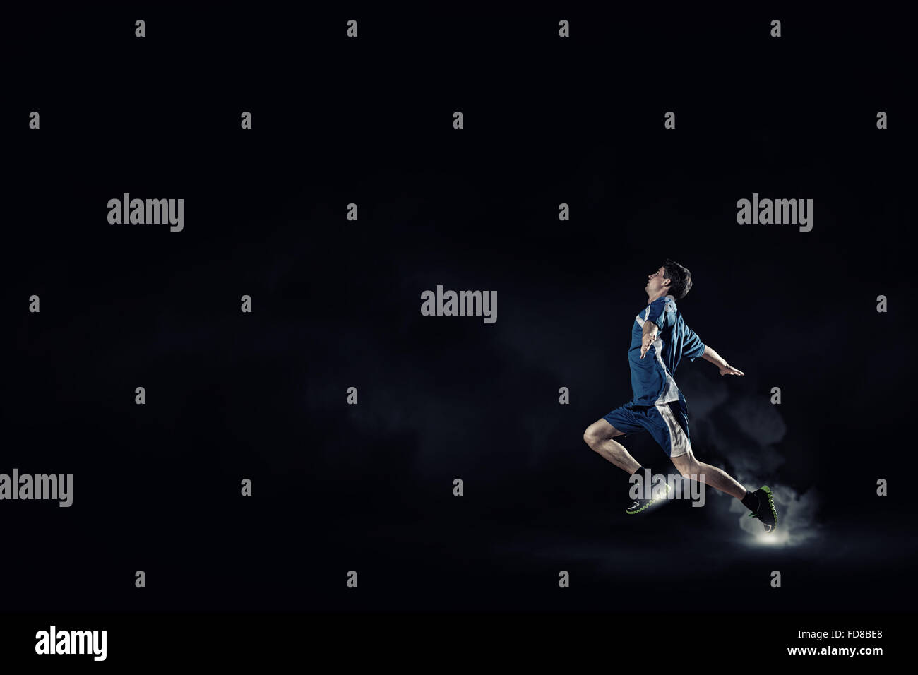Running man in blue sport wear on black background Stock Photo - Alamy
