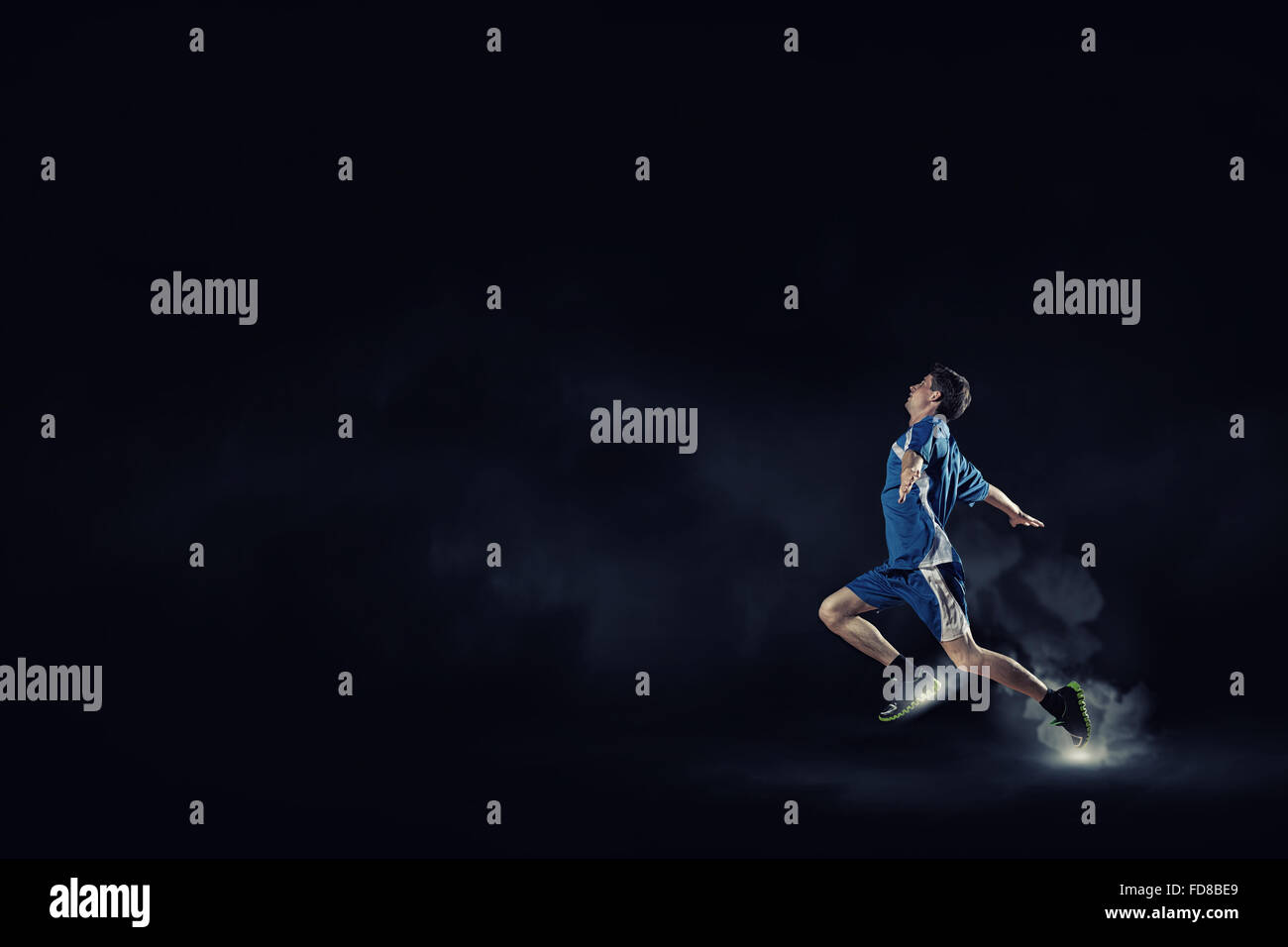 Running man in blue sport wear on black background Stock Photo - Alamy
