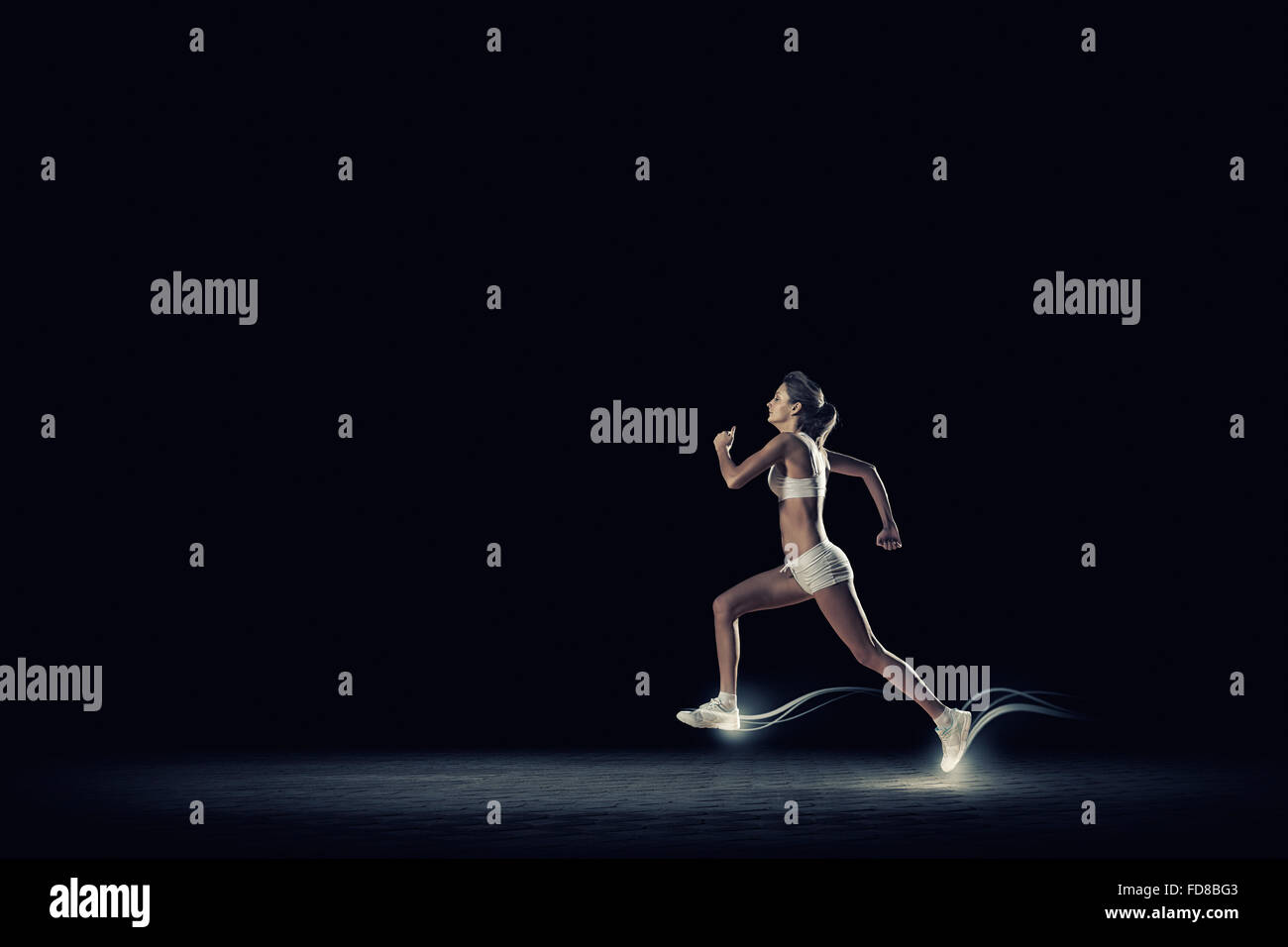 Running woman in sport wear on black background Stock Photo - Alamy