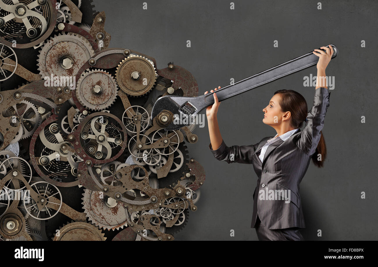 Young businesswoman fixing gears mechanism with wrench Stock Photo - Alamy