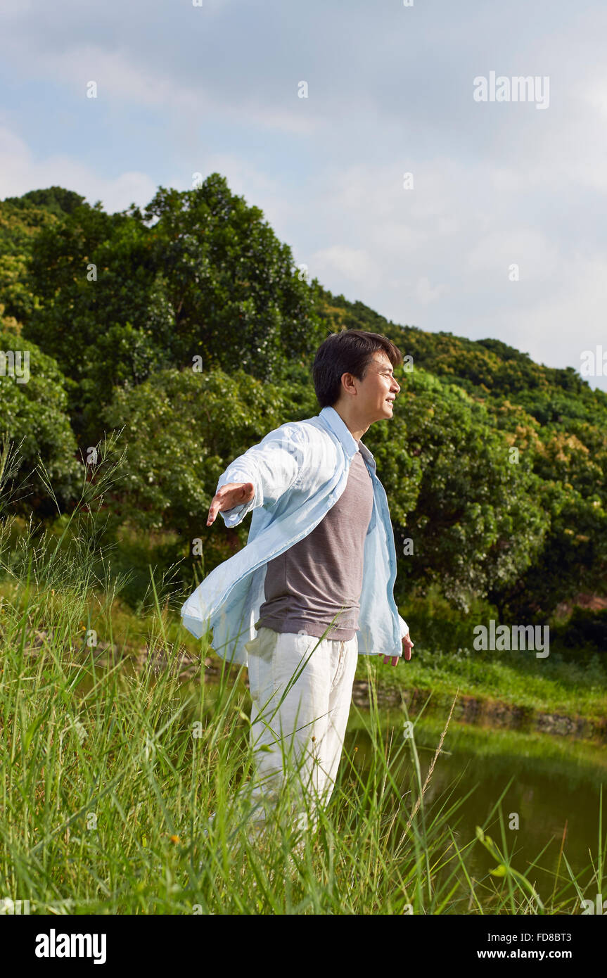 Chinese man outstretching arms in the wind in nature Stock Photo - Alamy