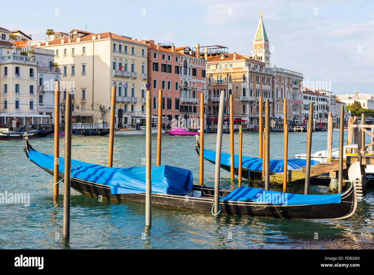 Beautiful traditional black gondolas docked to the poles on the Grand ...