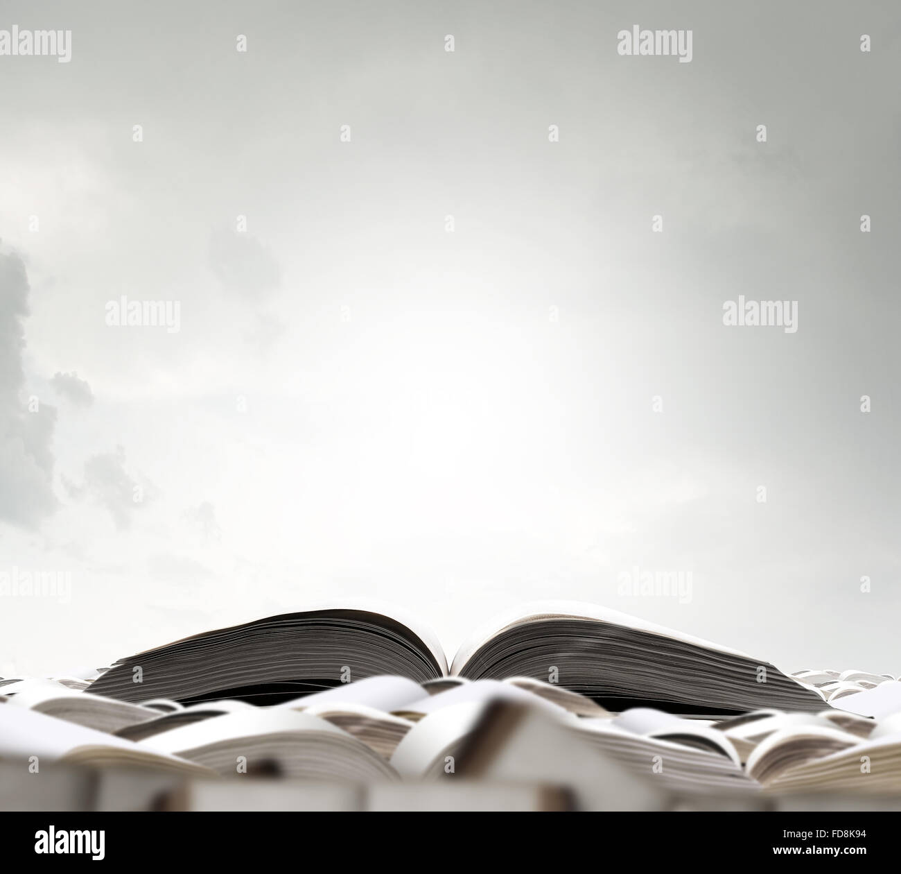 Pile of books with one book open on white background Stock Photo - Alamy