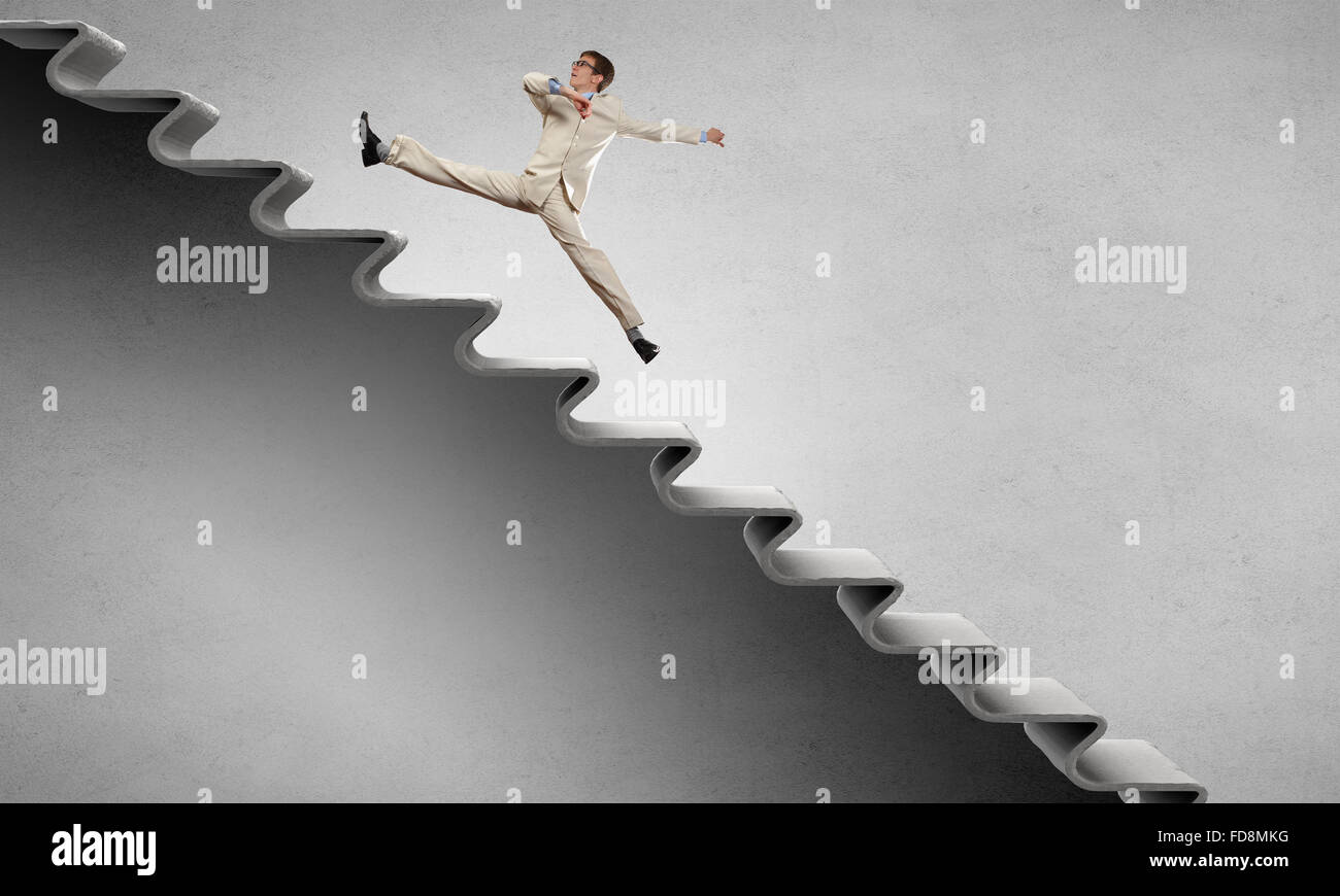 Young businessman walking up on staircase representing success concept ...