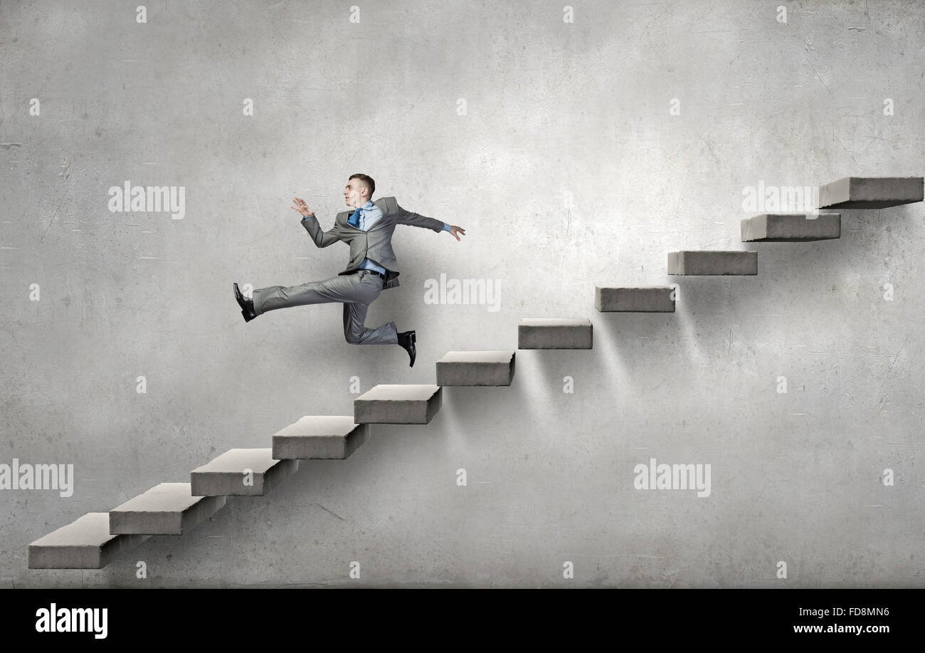 Young businessman walking up on staircase representing success concept ...