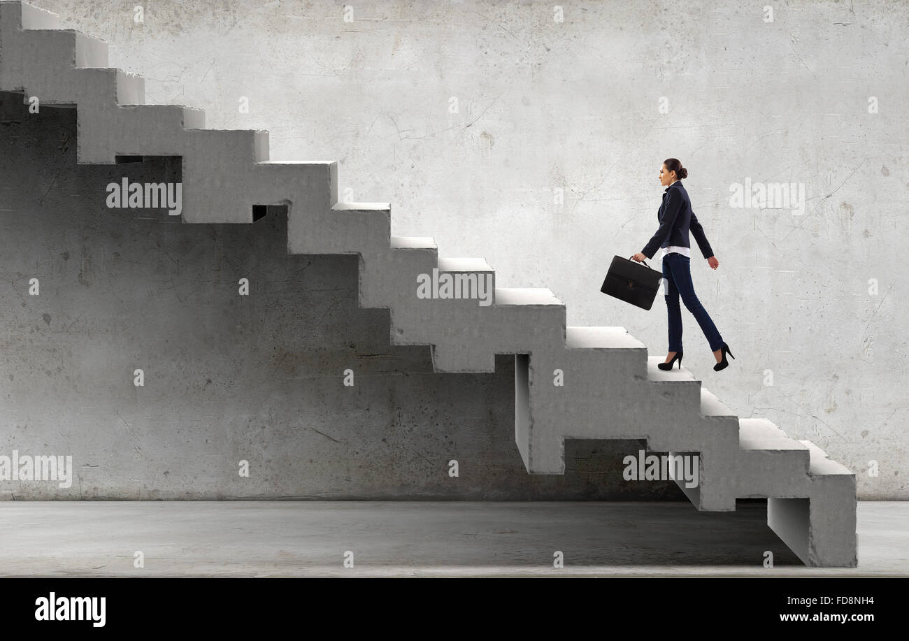 Young businesswoman walking up on staircase representing success ...