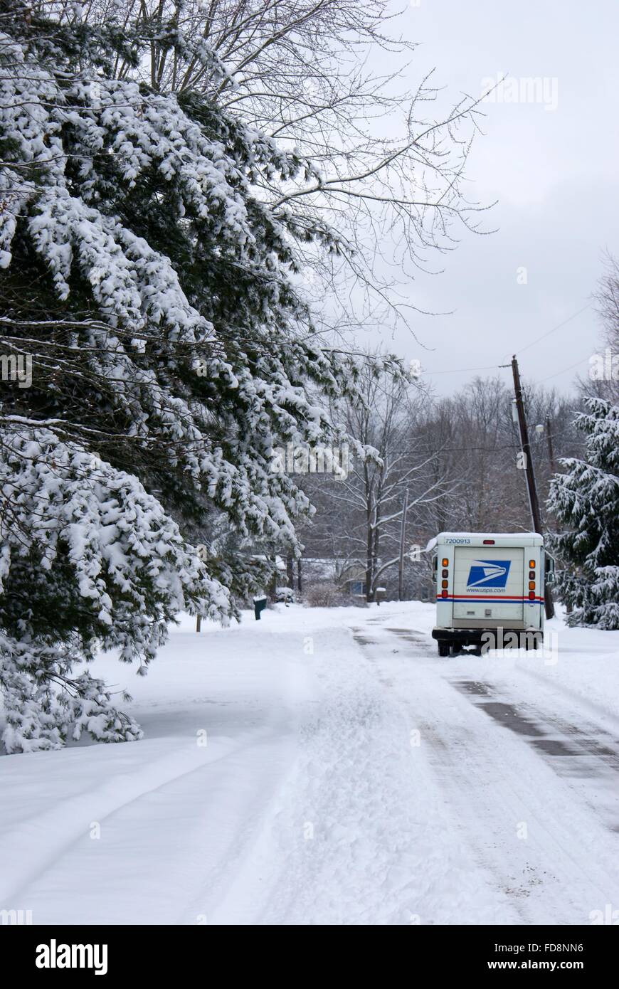A postal truck delivering mail in a neighborhood in the snow Stock ...