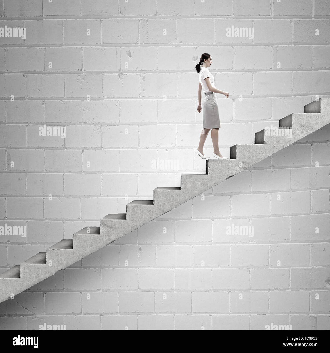 Young businesswoman walking up on staircase representing success ...