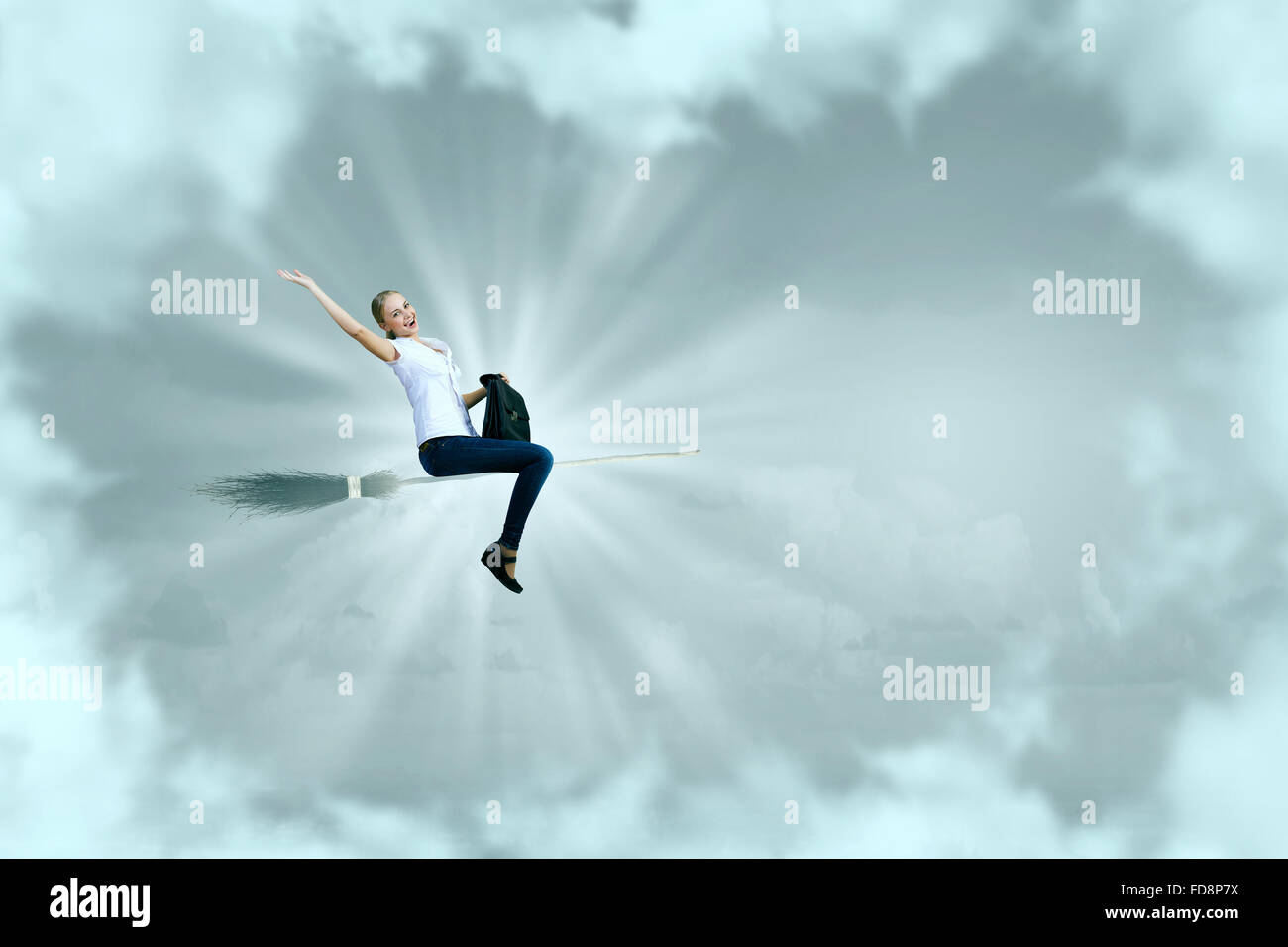 Happy young woman flying in sky on broom Stock Photo - Alamy