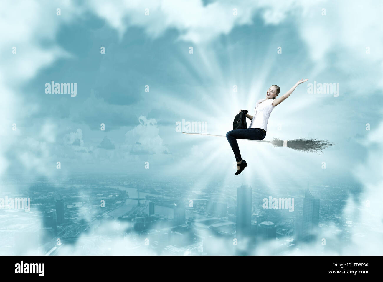 Happy young woman flying in sky on broom Stock Photo - Alamy