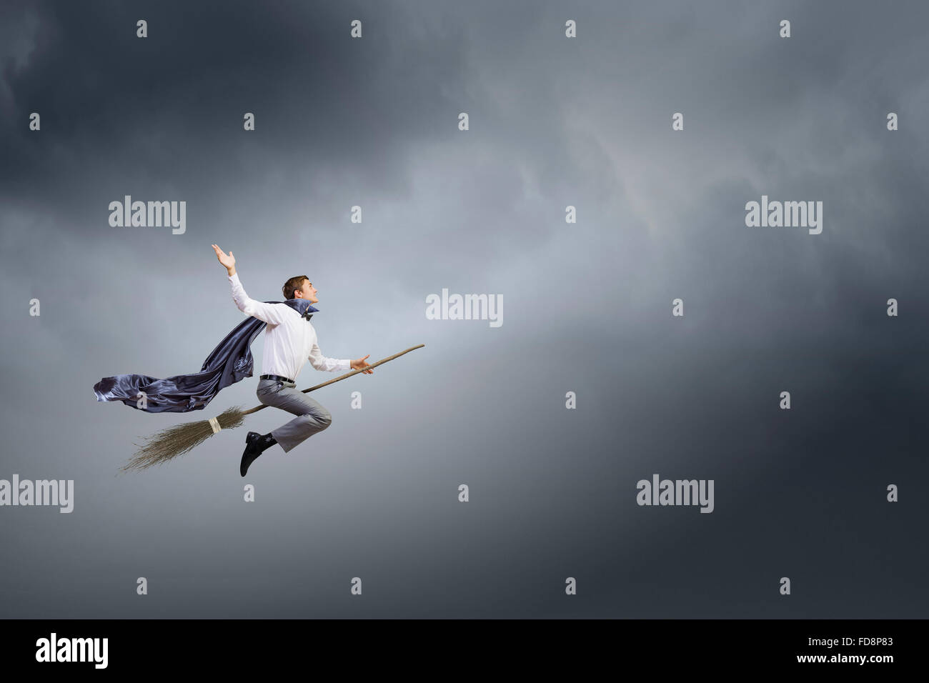 Young businessman flying on broom high in sky Stock Photo - Alamy