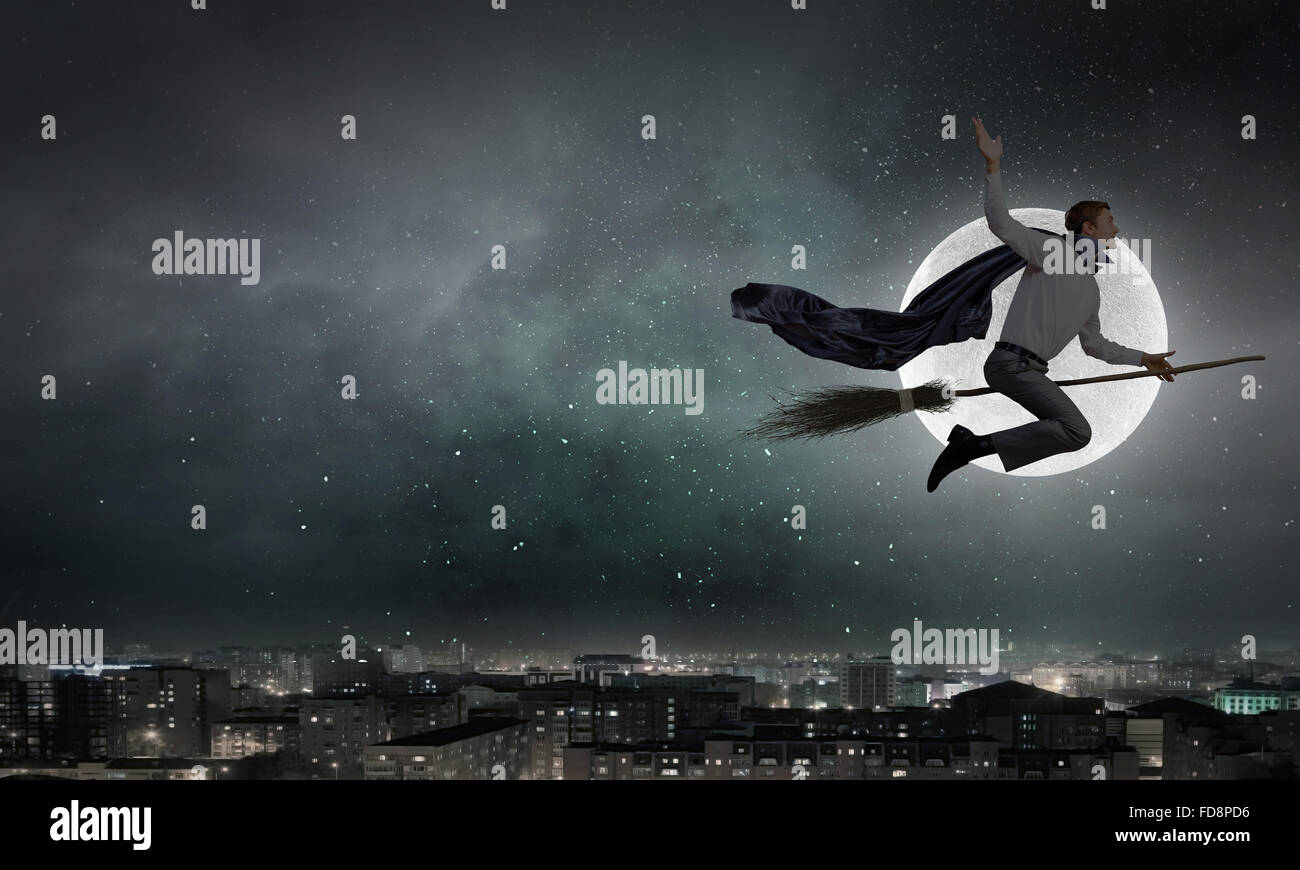 Young businessman flying on broom high in sky Stock Photo - Alamy