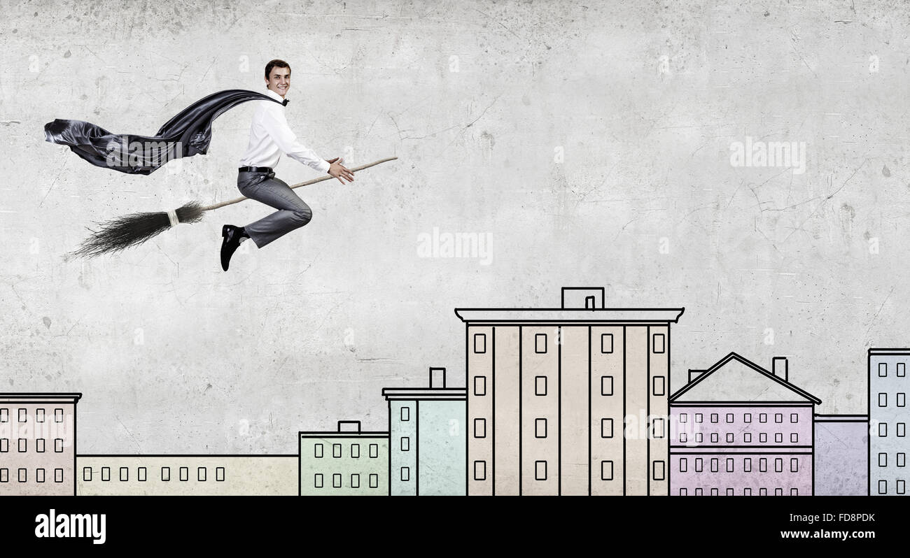 Young businessman flying on broom high in sky Stock Photo - Alamy